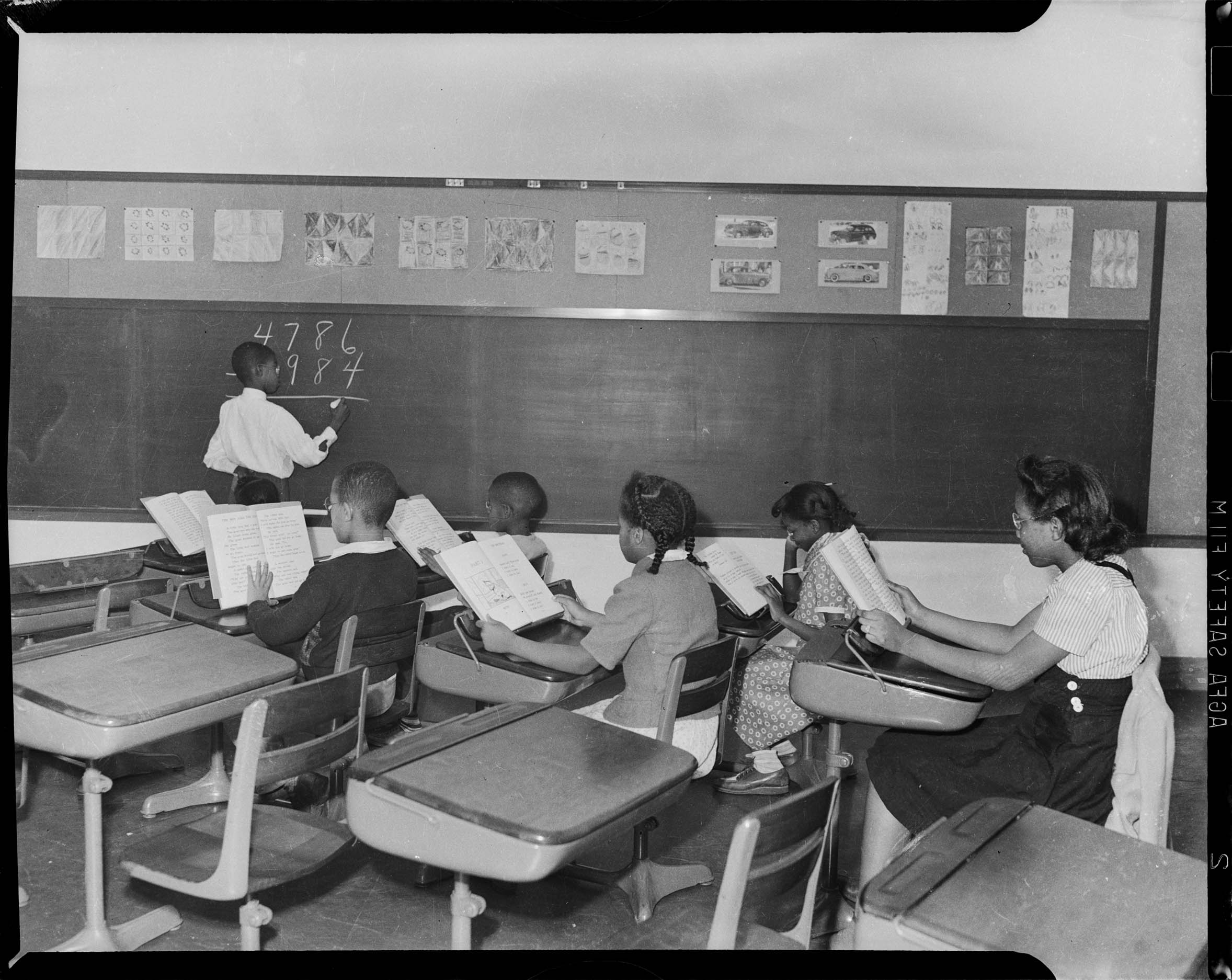 Boy Standing At Chalkboard Writing Math Equation 4786 984 With Two boy-standing-at-chalkboard-writing-math-equation-4786-984-with-two